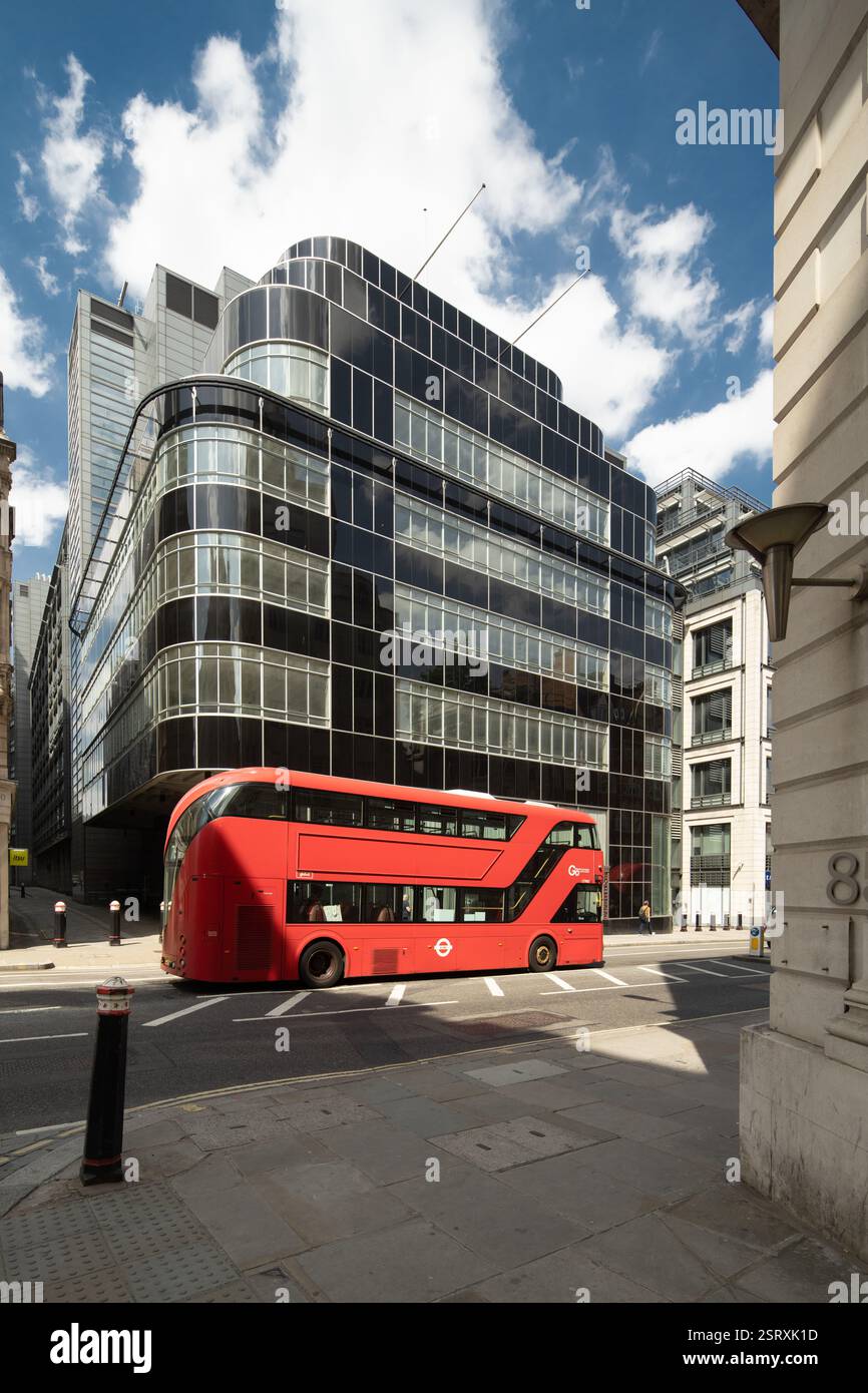 London, UK. A red London double-decker bus passes the iconic, Art Deco ...