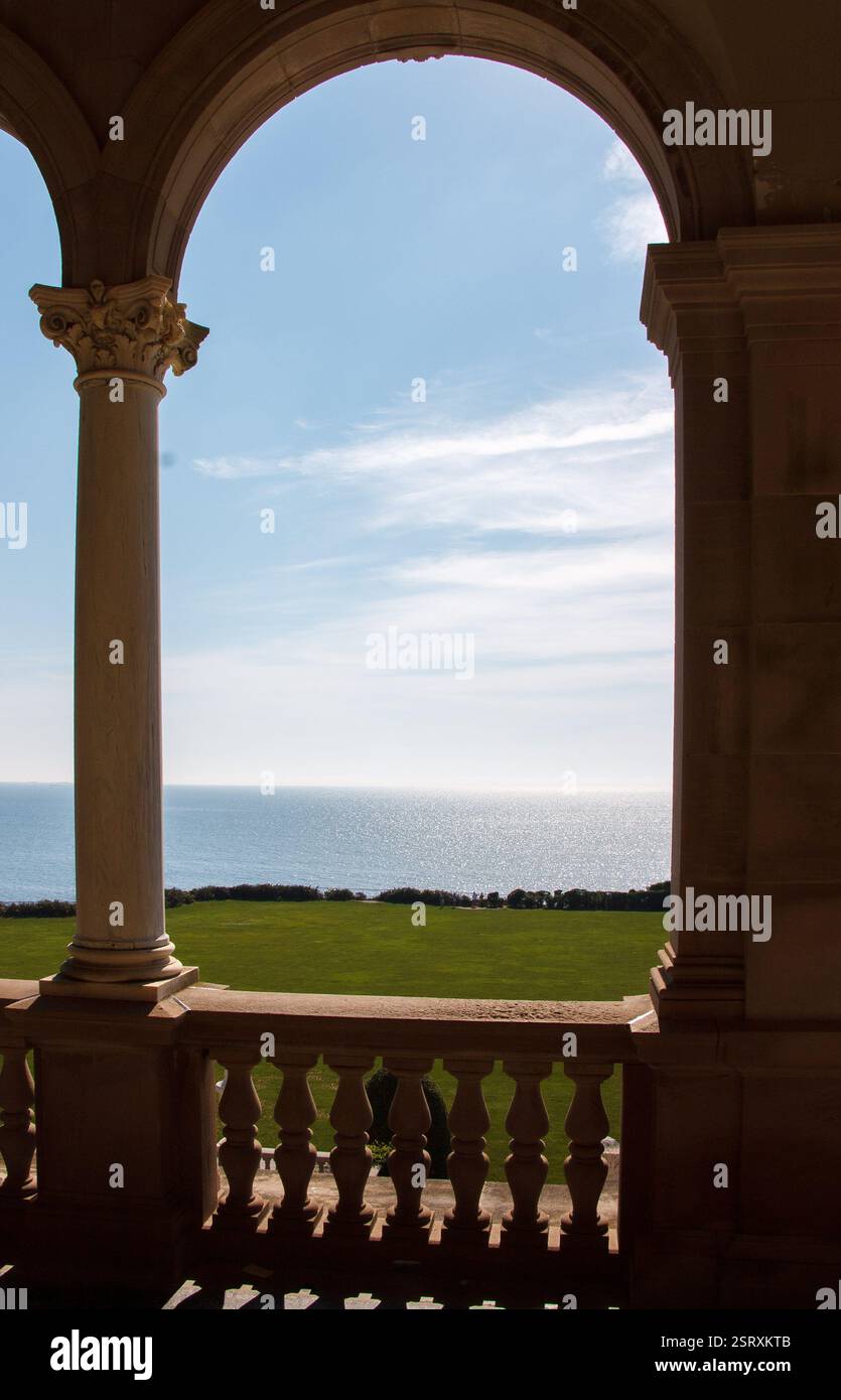 A Corinthian column and arch framing the glegant garden and the ocean ...