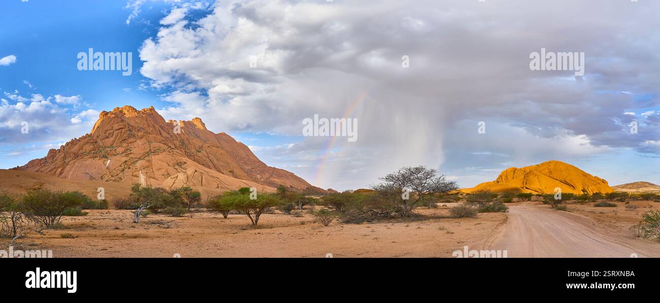 Little Spizkoppe mountain with a shower of rain and a rainbow in the ...