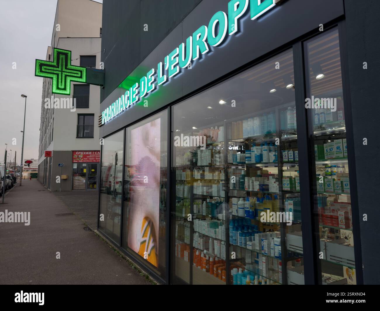 Innovative pharmacy storefront illuminated by vibrant green cross sign ...
