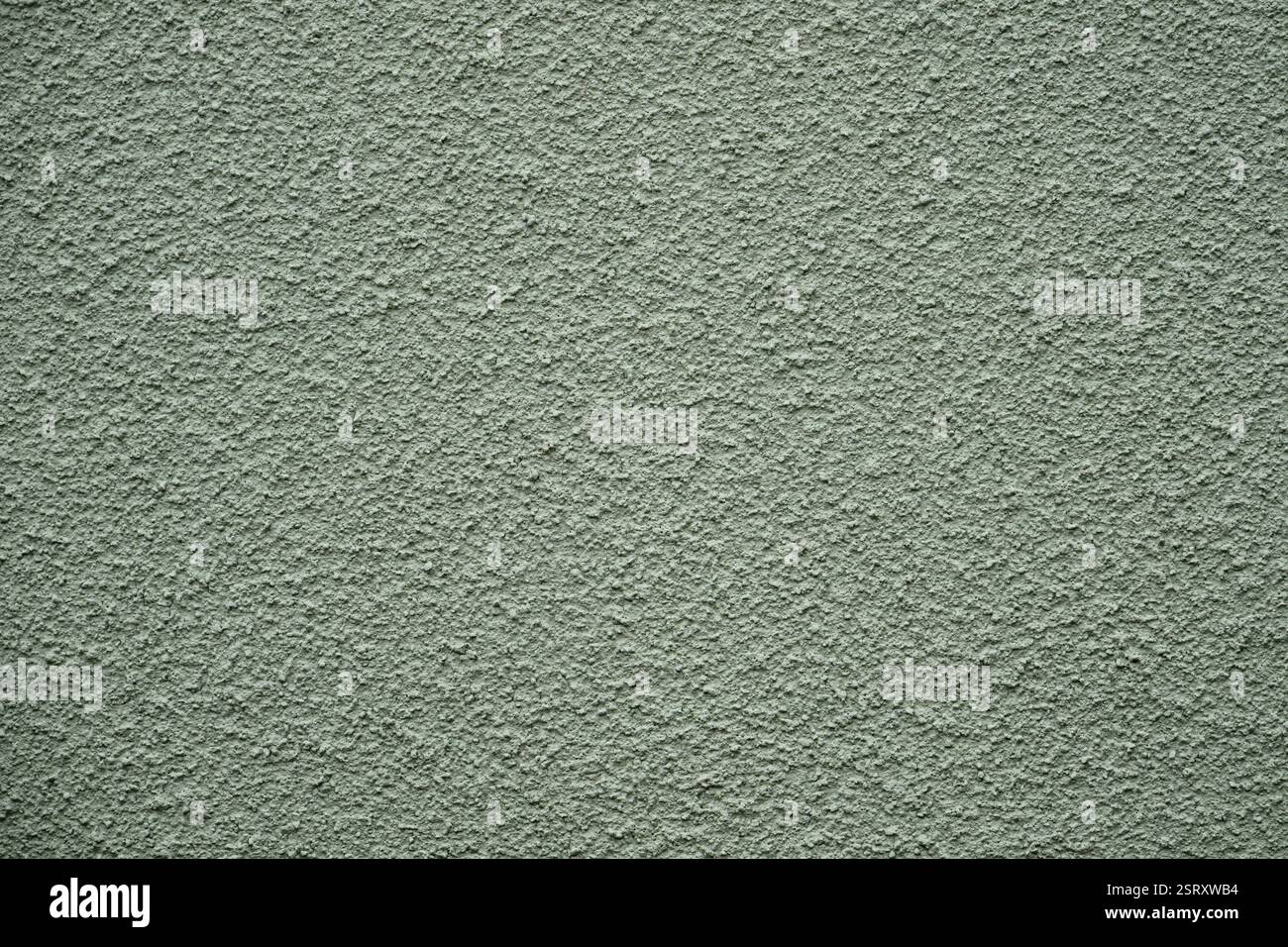 The rough texture of a green wall displays various shades and patterns ...
