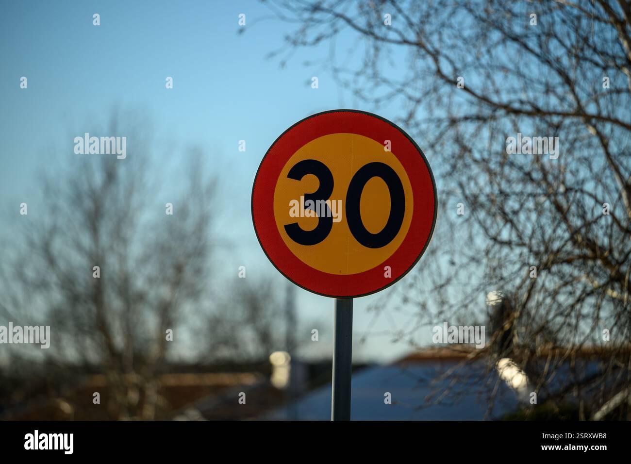 A clear blue sky serves as a backdrop for a vibrant speed limit sign ...