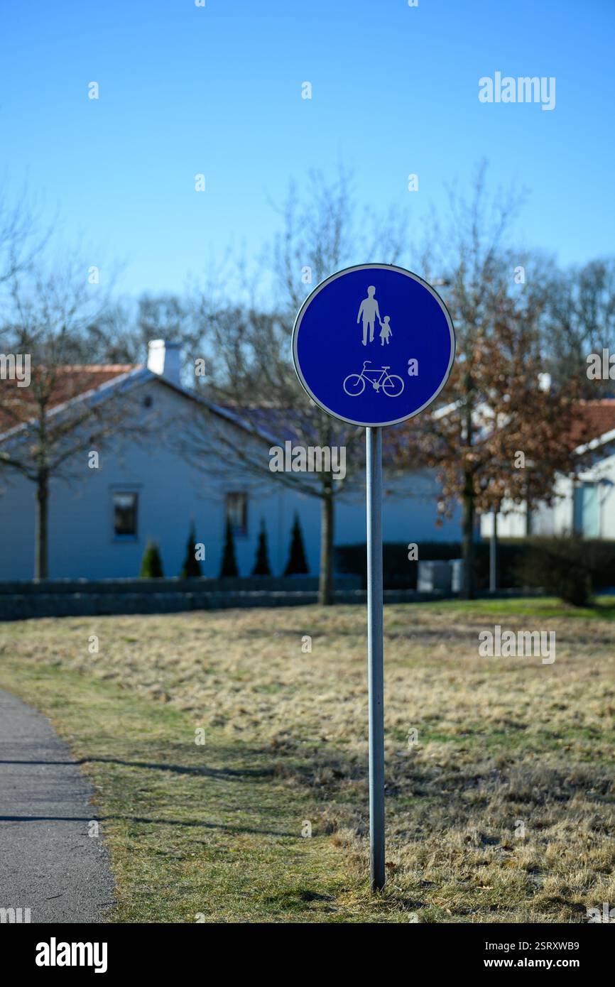A blue sign displays symbols for a pedestrian, child, and bicycle ...