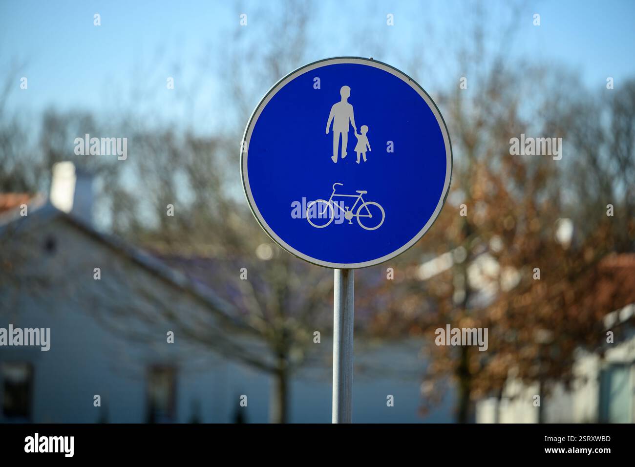 A blue sign displays symbols for a pedestrian, child, and bicycle ...