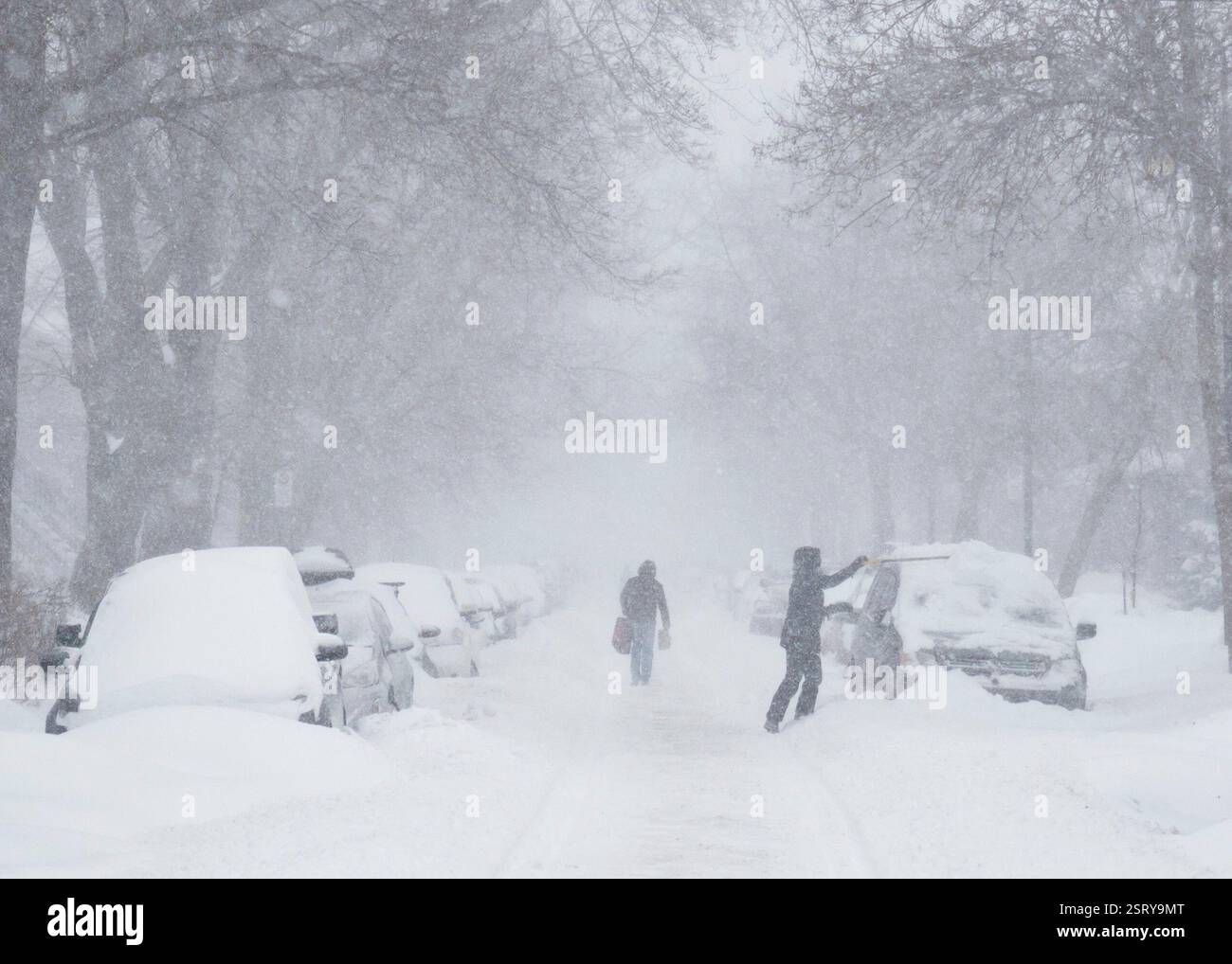A man walks down a s street during a heavy winter snowstorm in the ...