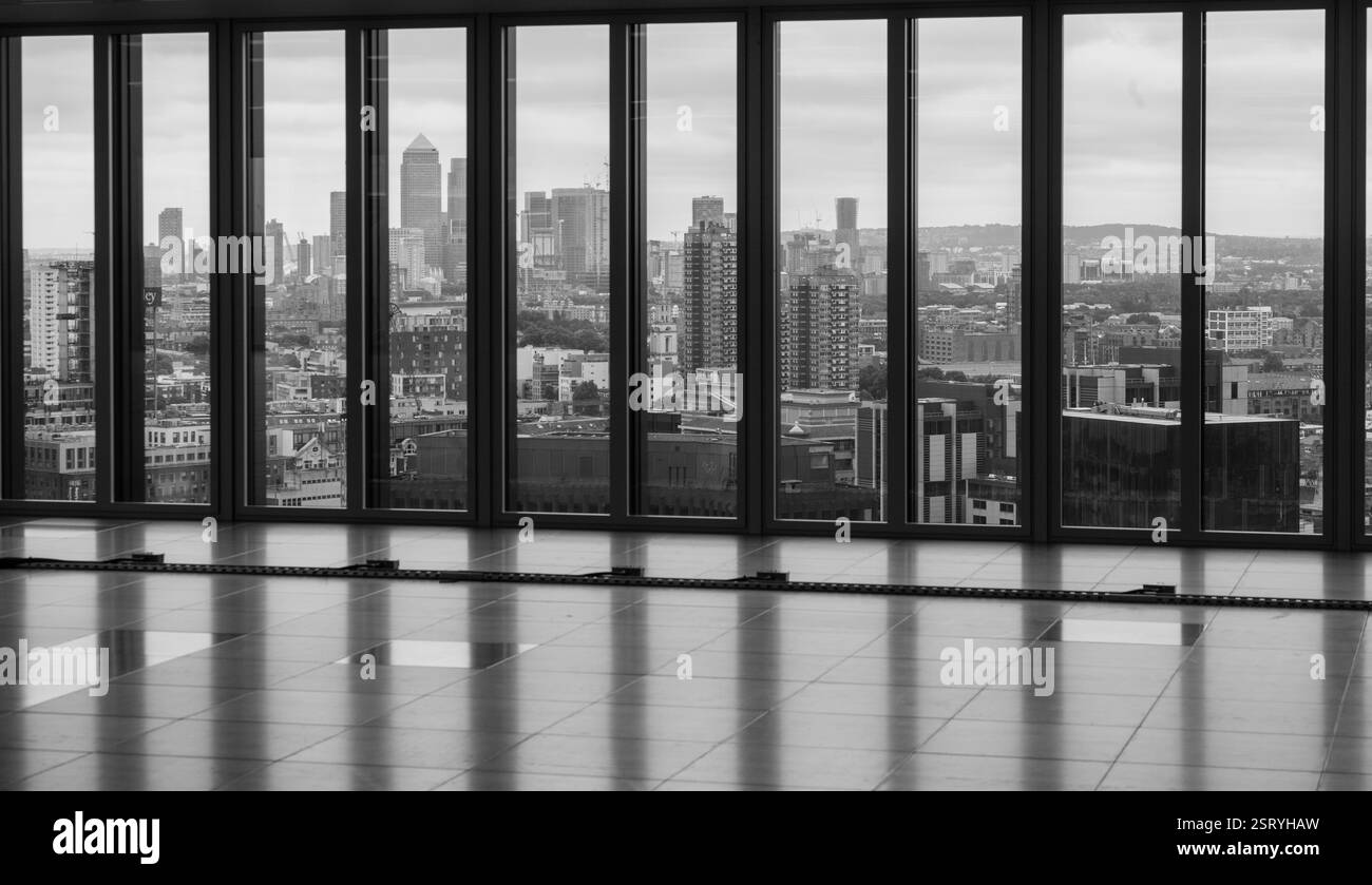 London skyline seen through ceiling high windows in an office building ...