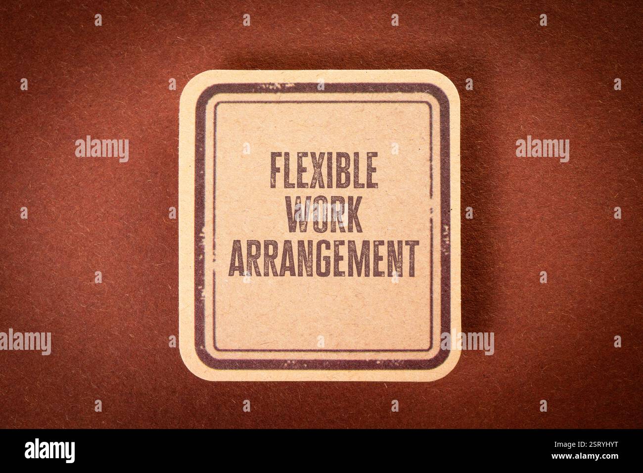 Flexible Work Arrangement. Cardboard sticker with text on a brown ...