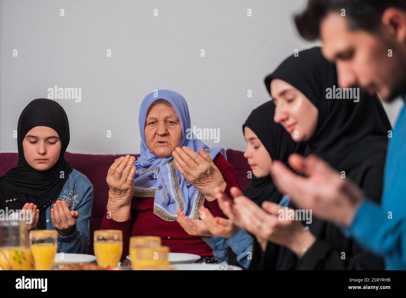 Muslim family together making iftar dua to break fasting during Ramadan ...