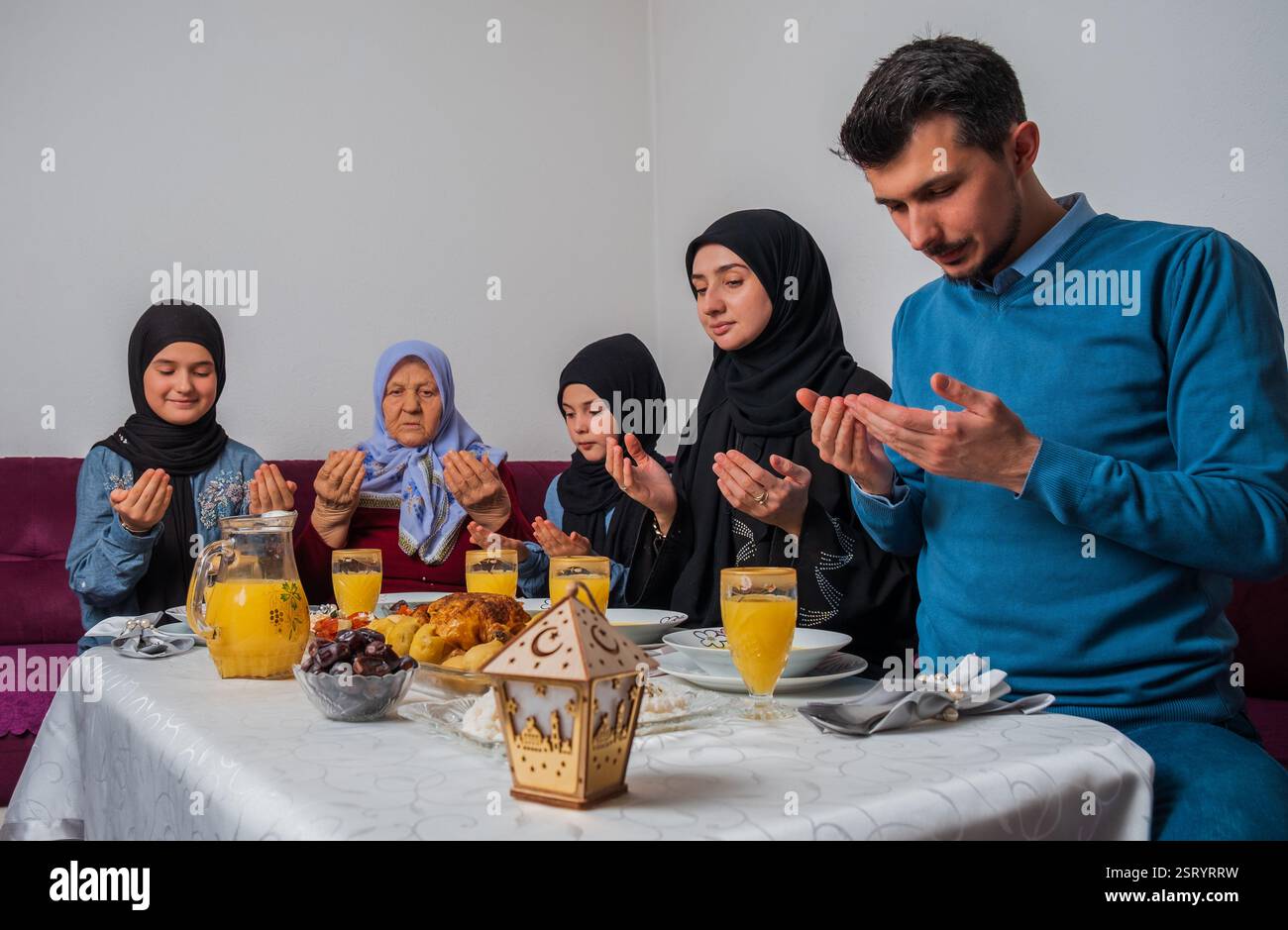 Muslim family making iftar dua to break fasting during Ramadan happy ...