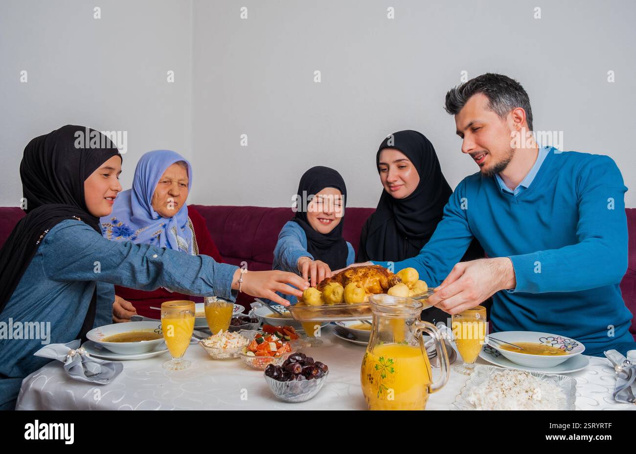 Happy Muslim family having iftar dinner to break fasting during Ramadan ...