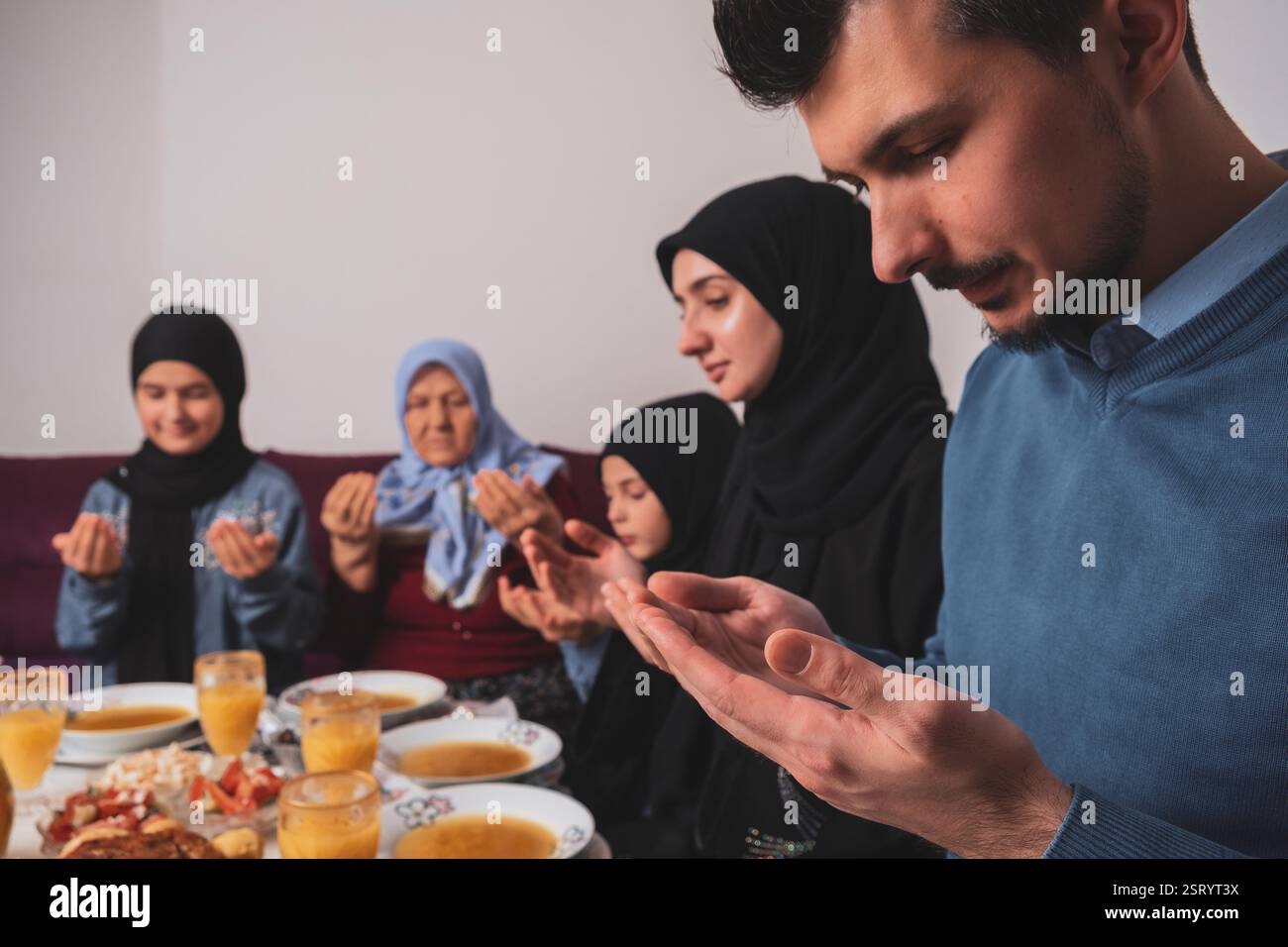 Muslim family making iftar dua to break fasting during Ramadan happy ...