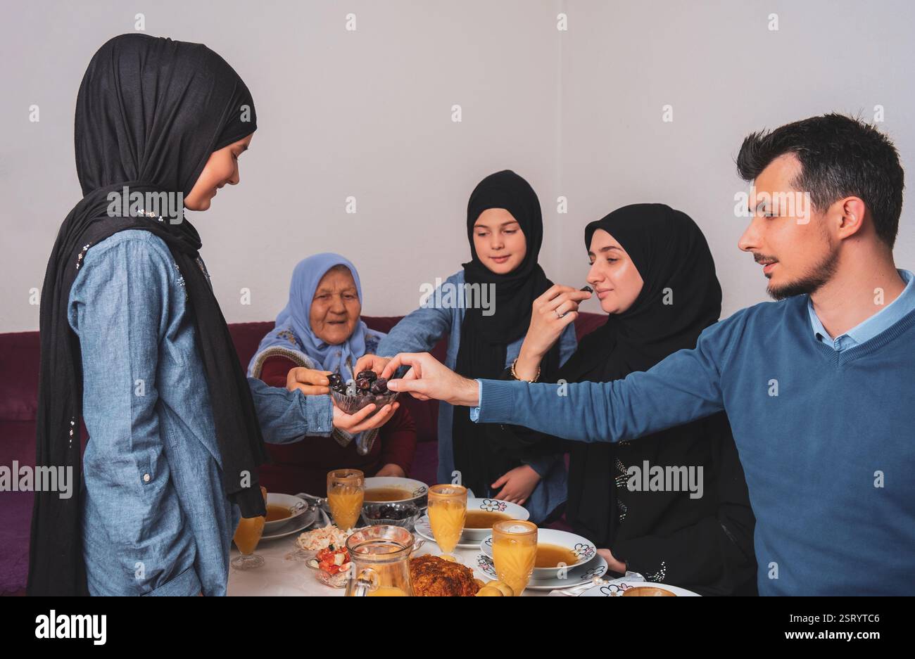 Happy Muslim family having iftar dinner at home during Ramadan dining ...