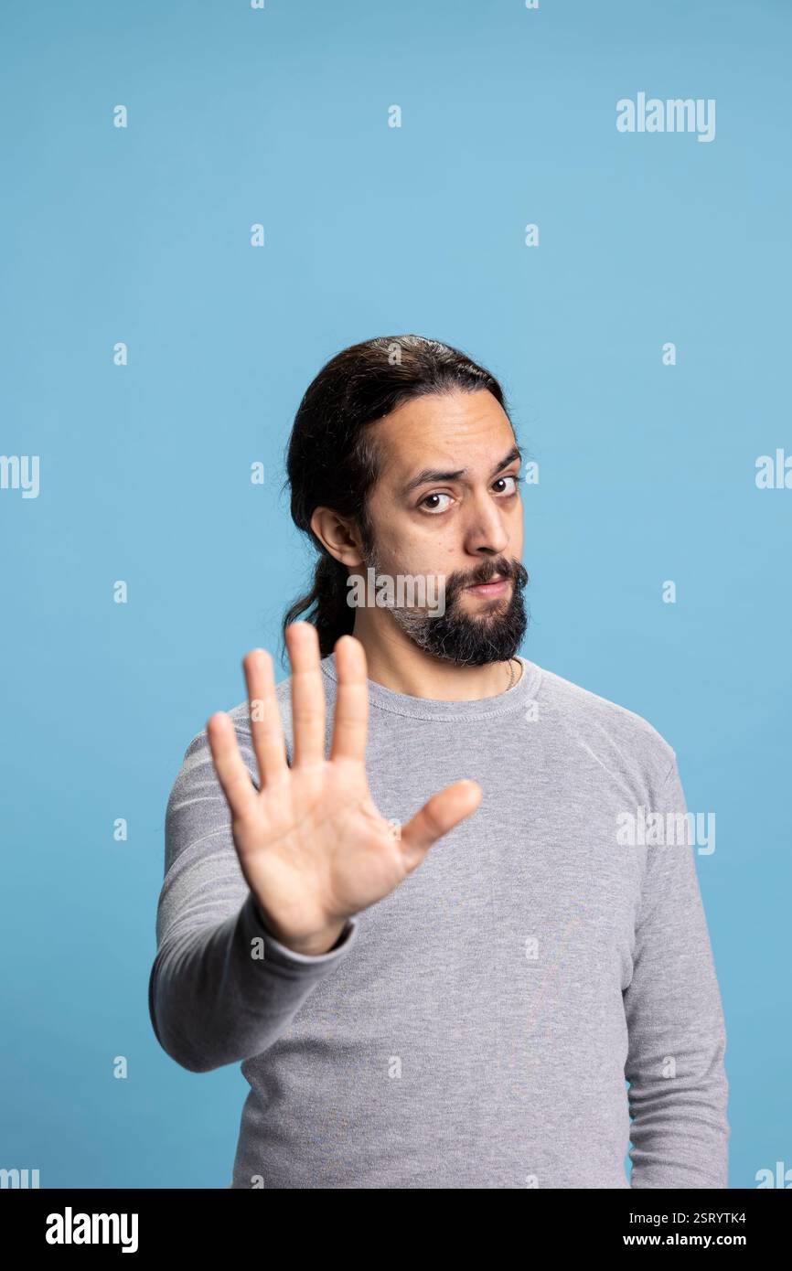 Young serious person expressing rejection with his palm raised, showing ...