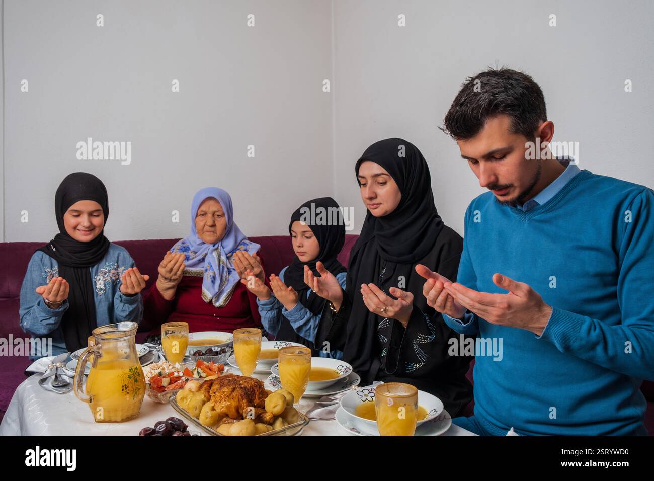 Muslim family making iftar dua to break fasting during Ramadan happy ...