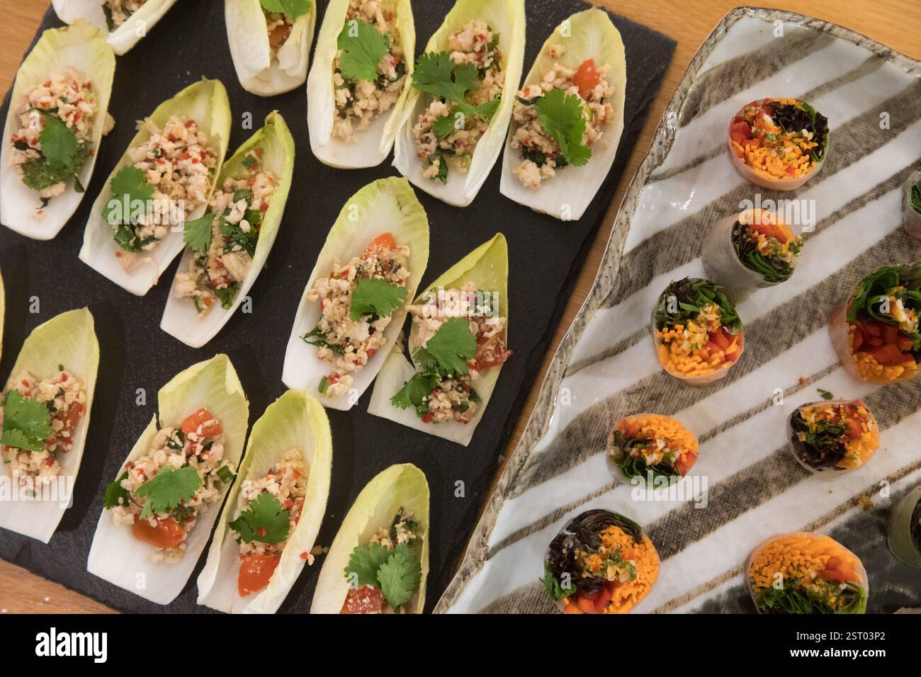 Thai-inspired appetizers. Chicken salad in chicory leaves and vegetable ...