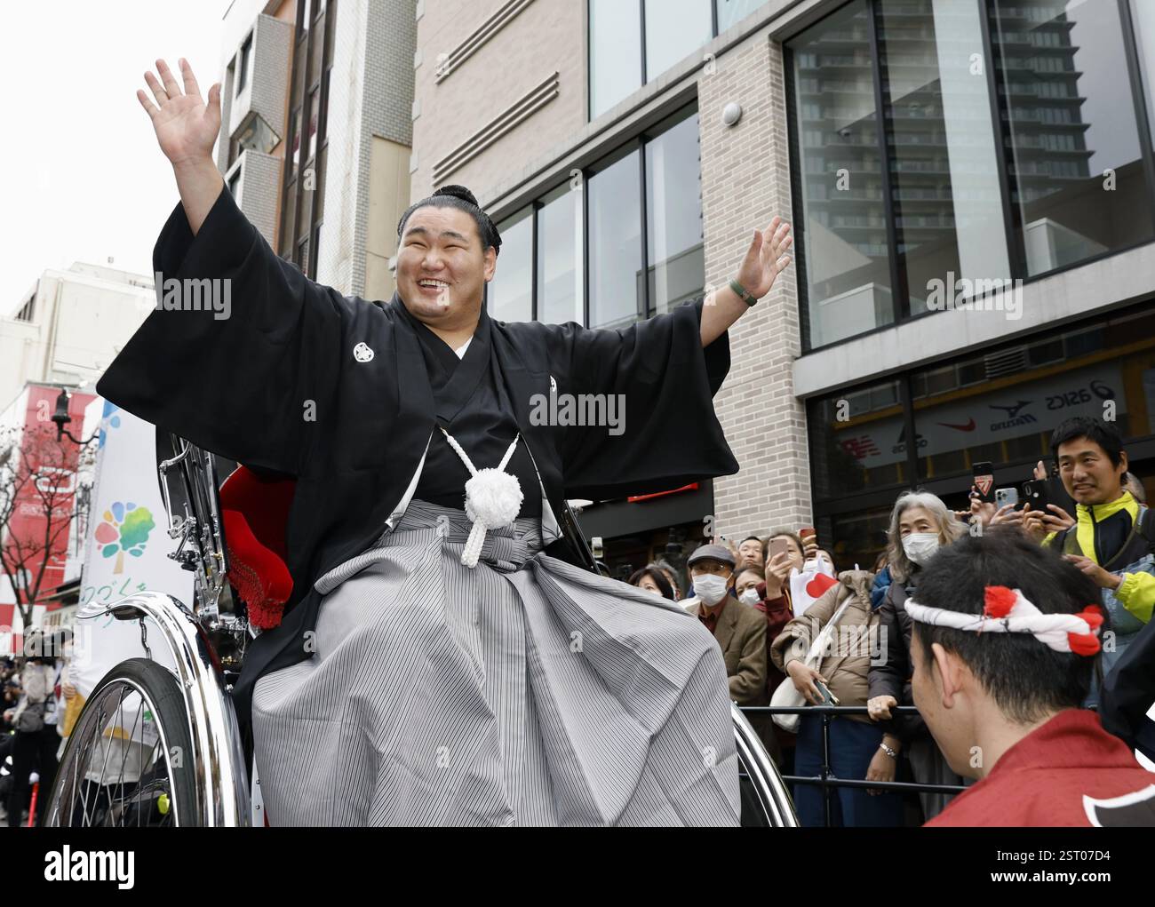 New sumo grand champion Hoshoryu waves to the crowd during a parade ...