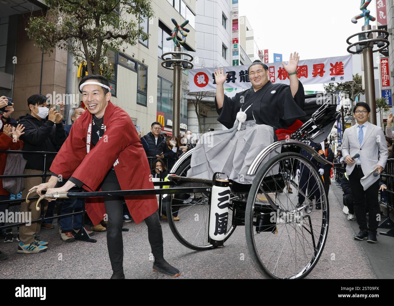 New sumo grand champion Hoshoryu waves to the crowd during a parade ...