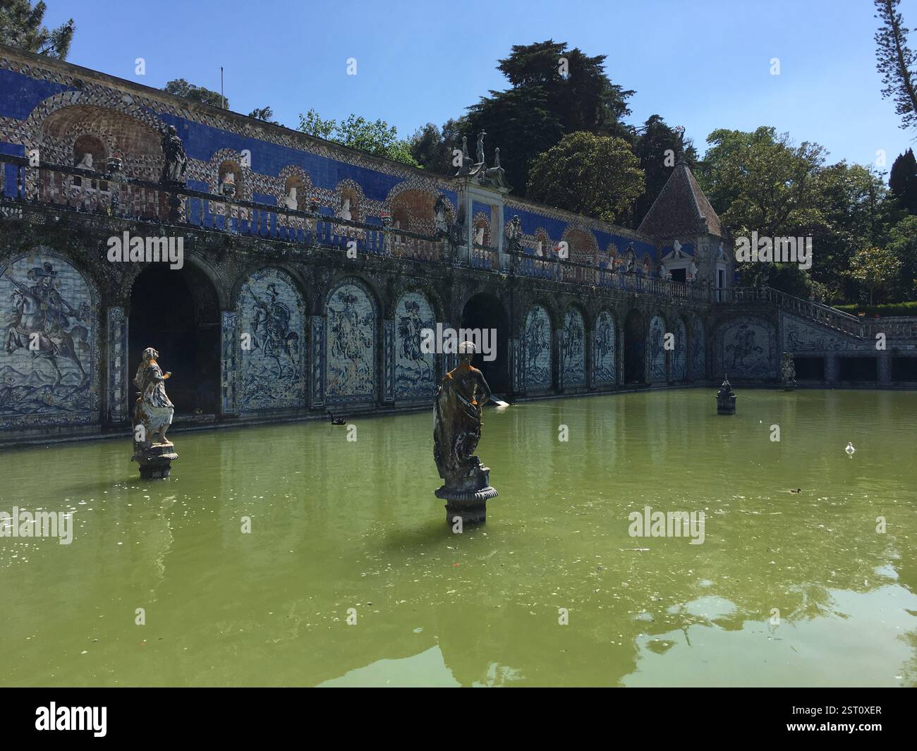 Waterfront. Colorful tiled wall with statues. Fountains and lush ...