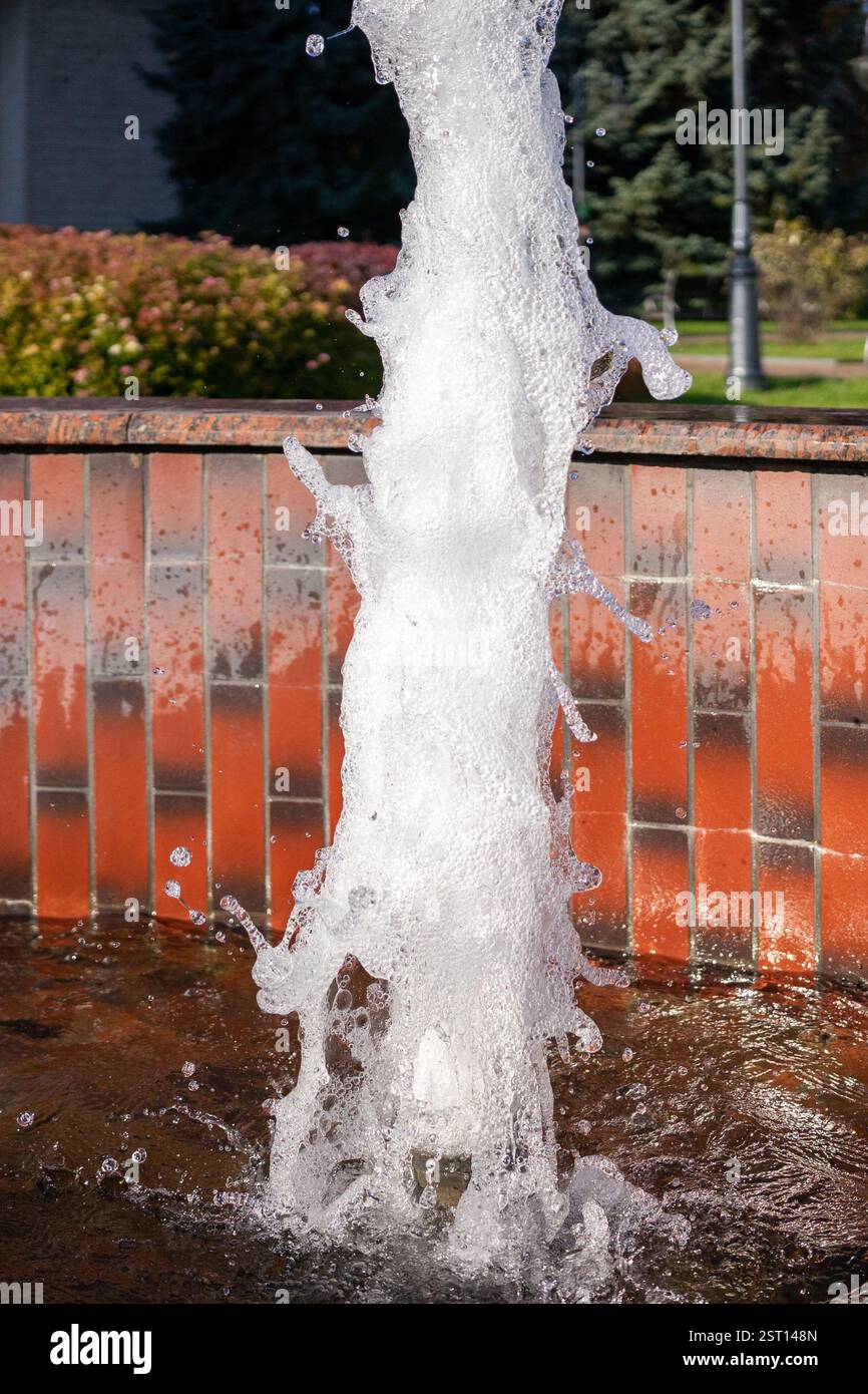 Water erupts from a fountain, sending droplets sparkling in the sun ...