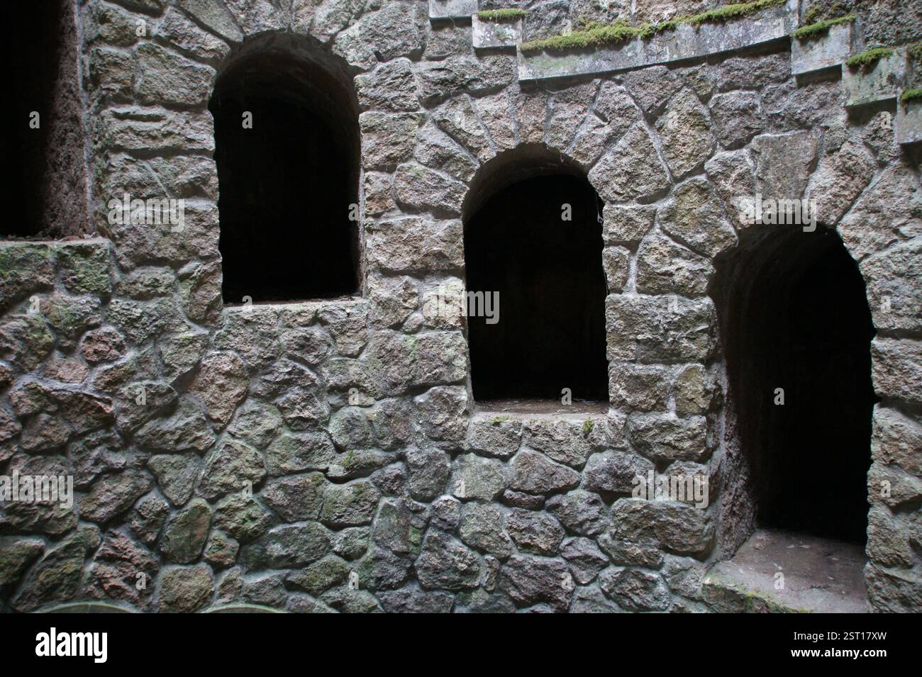 Stone spiral staircase descends into a dark, cavernous well. Sintra ...