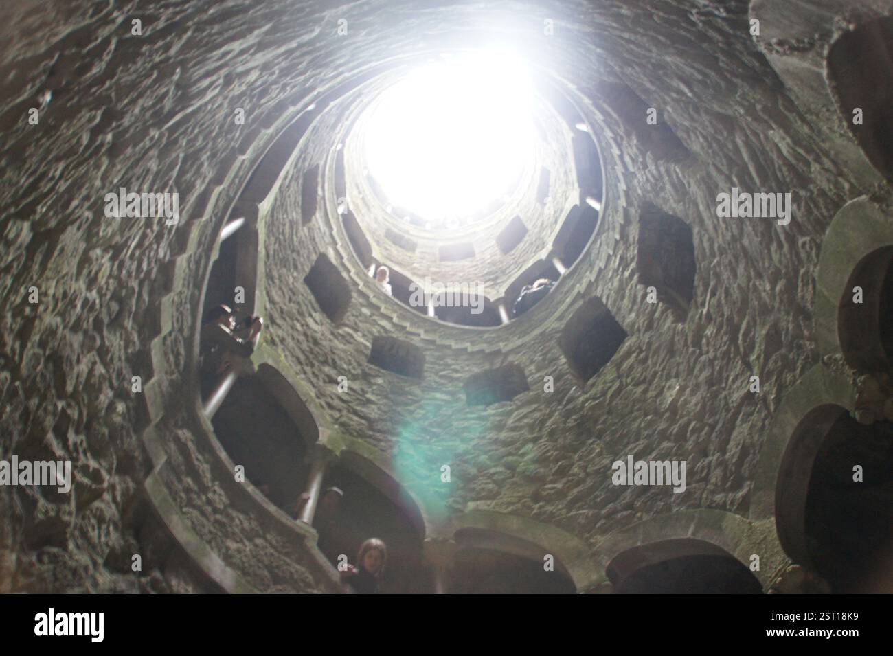 Sintra, Portugal. A winding stone staircase spirals downward ...