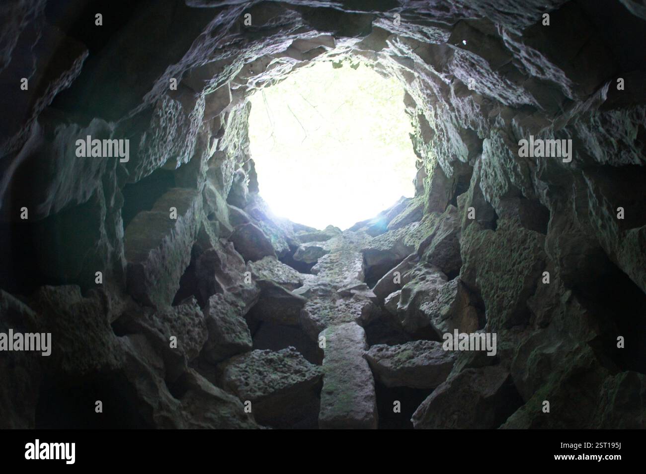 Stone well with intricate spiral staircase descends into darkness ...
