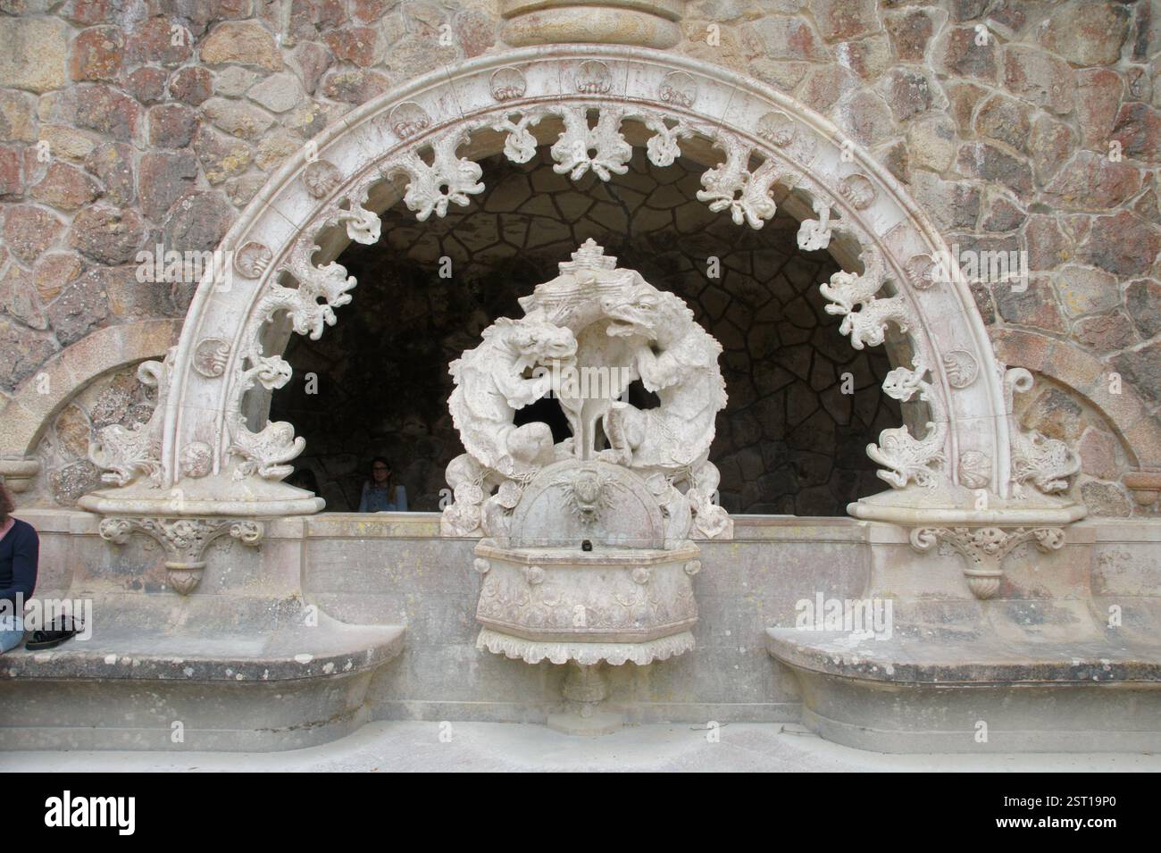 A majestic, ancient oak tree dominates the scene, its sprawling ...