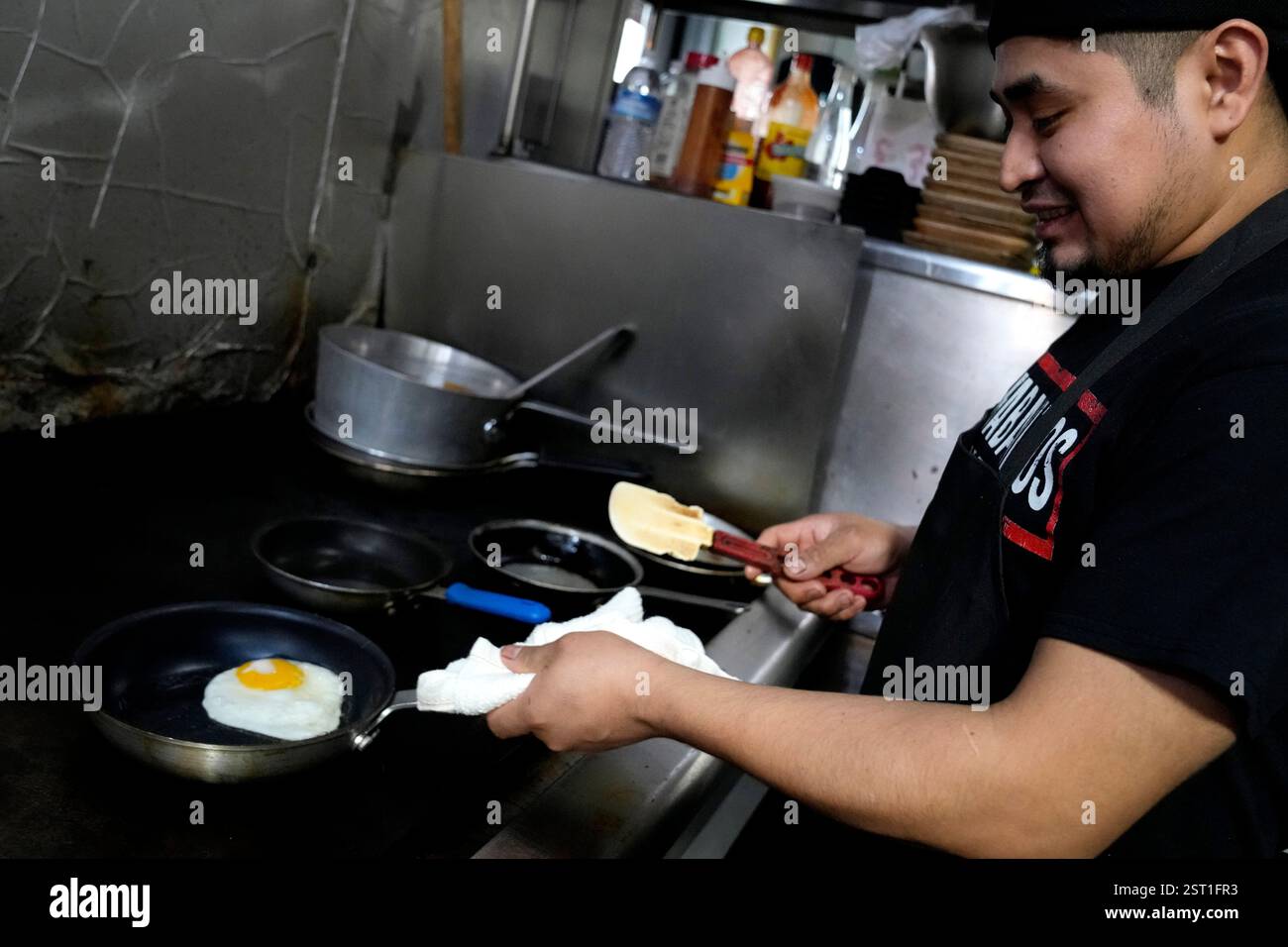Roger Carlos cooks eggs in a pan in the kitchen of 5 Rabanitos ...