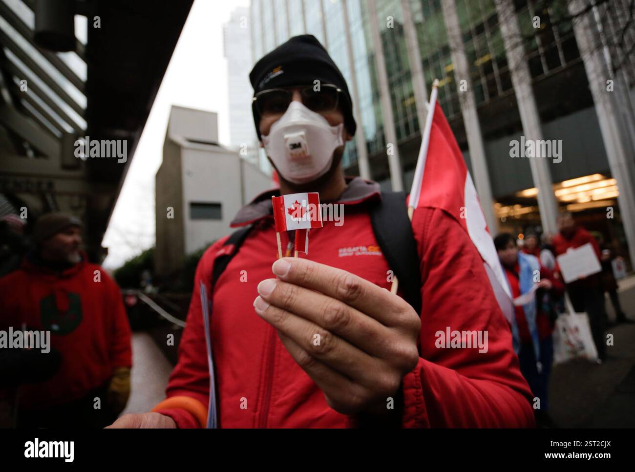 Beijing, Canada. 15th Feb, 2025. A man holds a mini Canadian flag at a ...