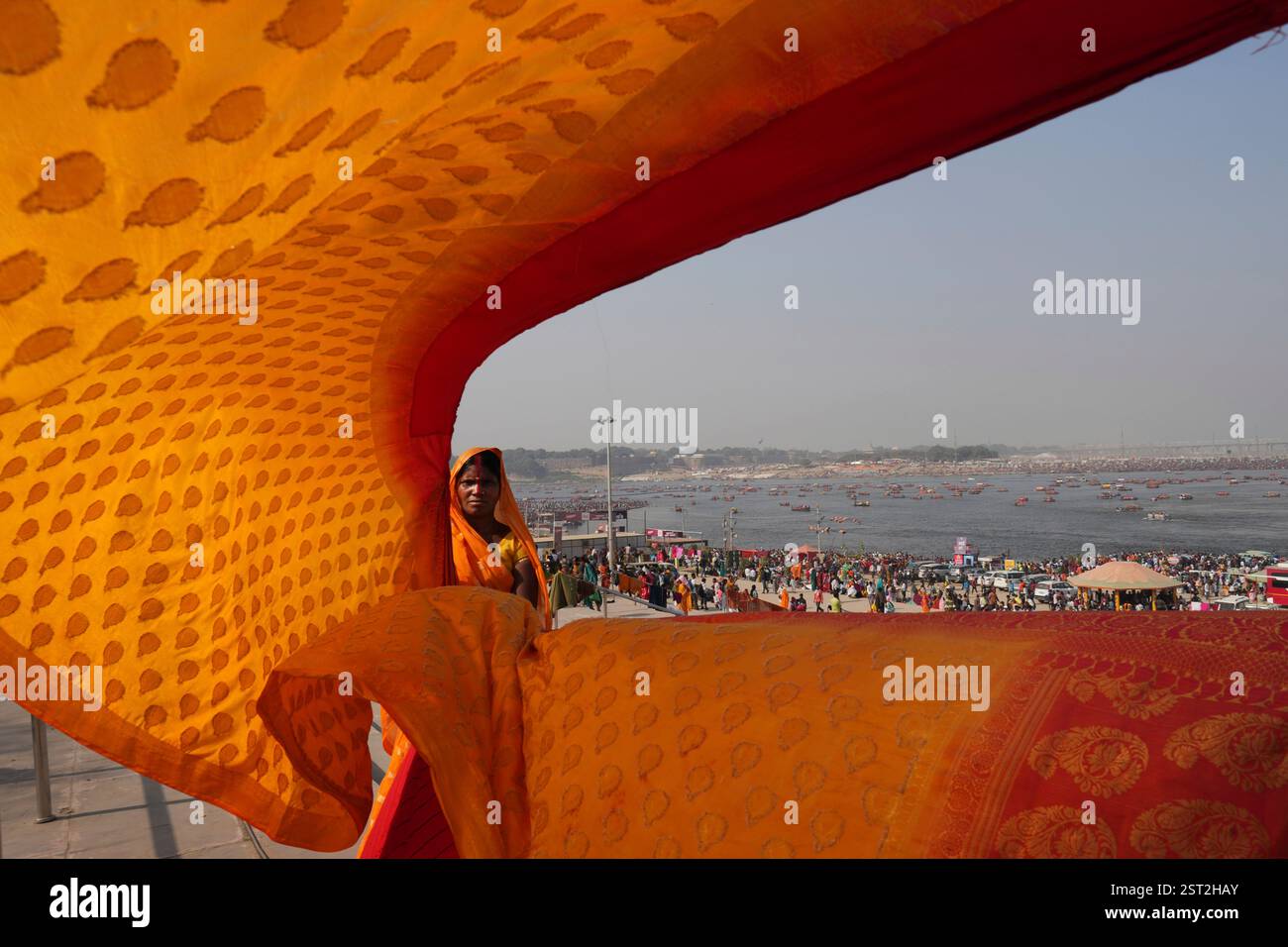 A pilgrim dries her sari after a holy dip at the confluence of the ...
