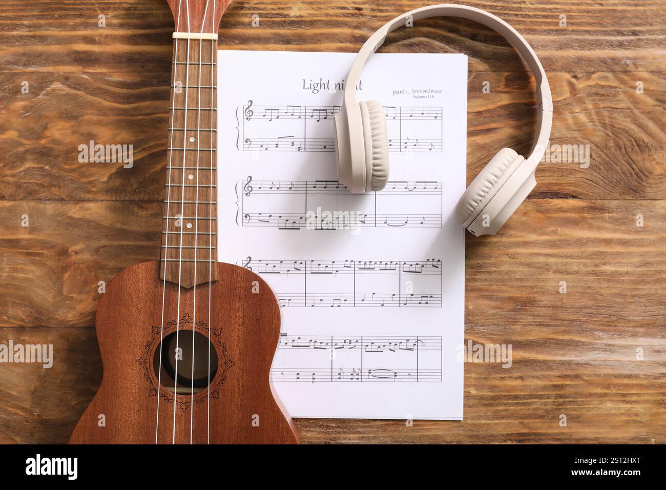 Ukulele, music sheet and modern headphones on wooden background Stock ...