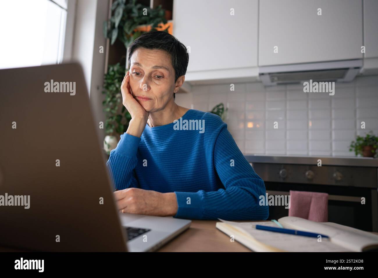 Tired mature woman overwhelmed by laptop work even at home. Remote work ...