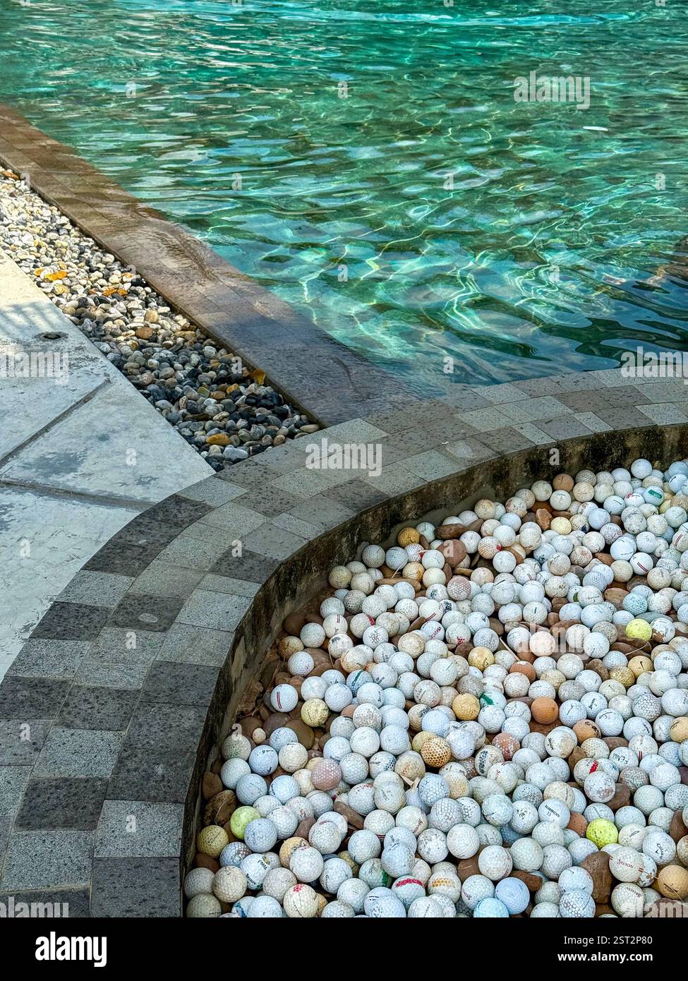 Pool with Stone Border and Used Golf Balls A turquoise swimming pool ...