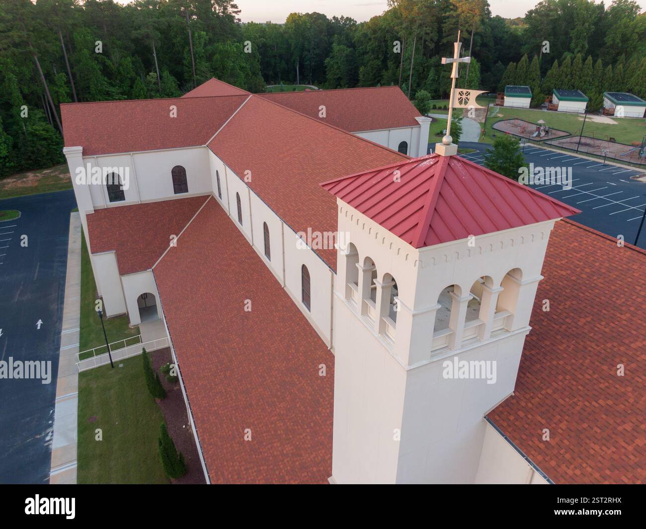 Afternoon Drone Images of a Cross Shaped Church With Red Asphalt ...