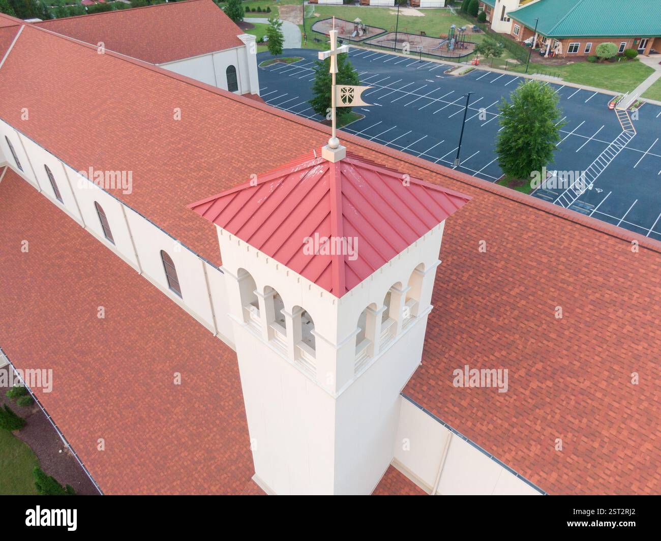 Afternoon Drone Images of a Cross Shaped Church With Red Asphalt ...