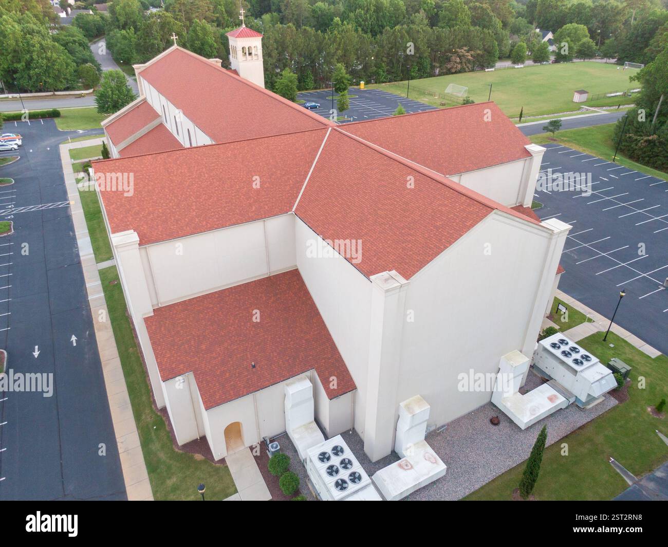 Afternoon Drone Images of a Cross Shaped Church With Red Asphalt ...