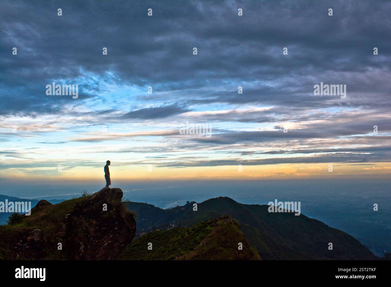 A silent figure meets the morning sky, lost in the breath of dawn Stock ...