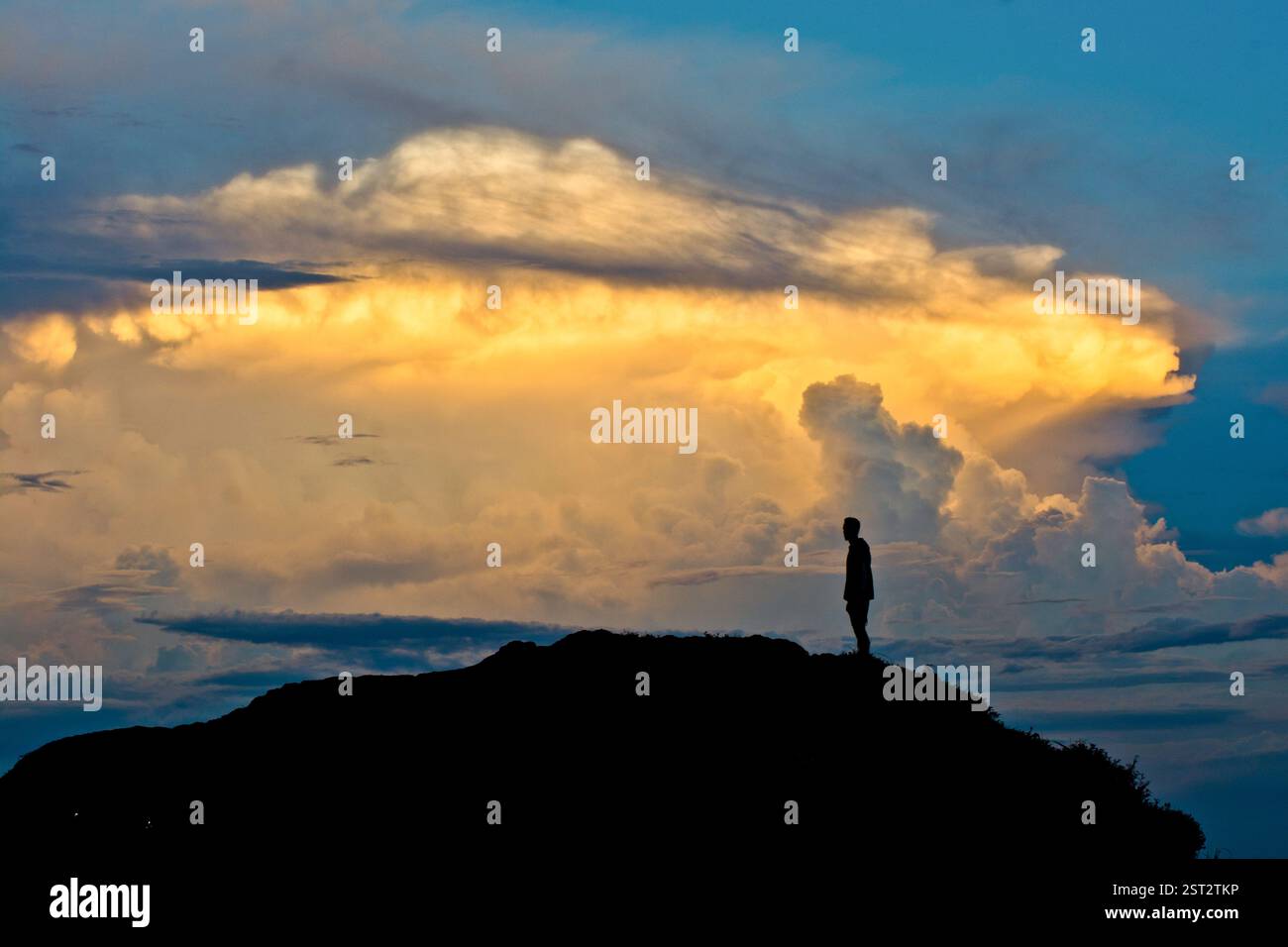 A silent figure meets the morning sky, lost in the breath of dawn Stock ...