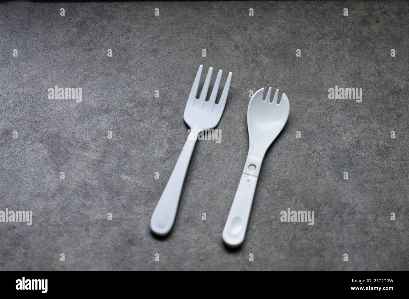 Two White Plastic Utensils on a Smooth Gray Surface Stock Photo - Alamy