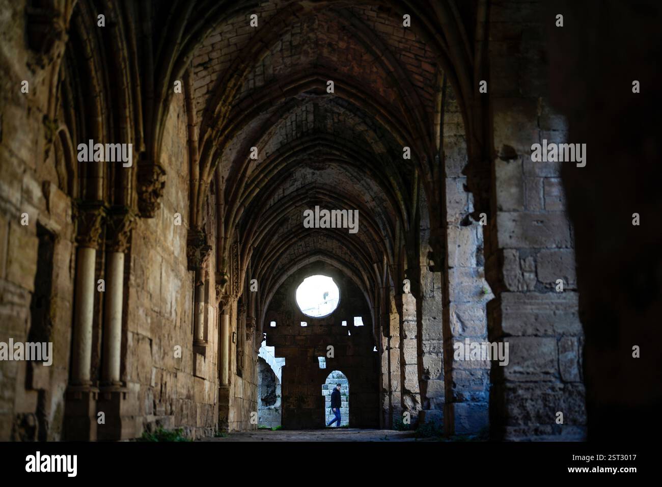 A man walks past the arches of the Knights' Stables in Krak des ...