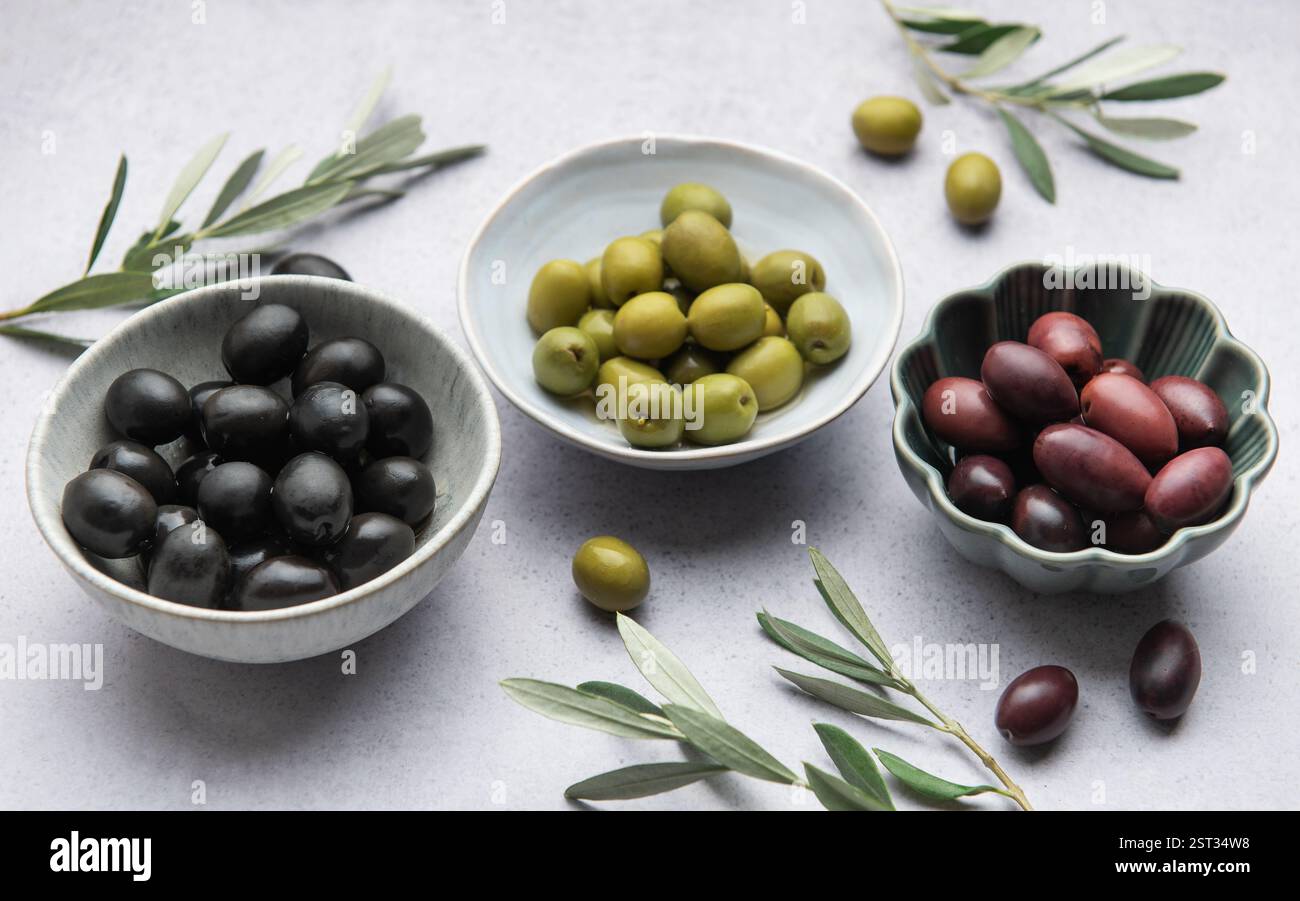 Black, green, and kalamata olives are served in bowls with olive ...