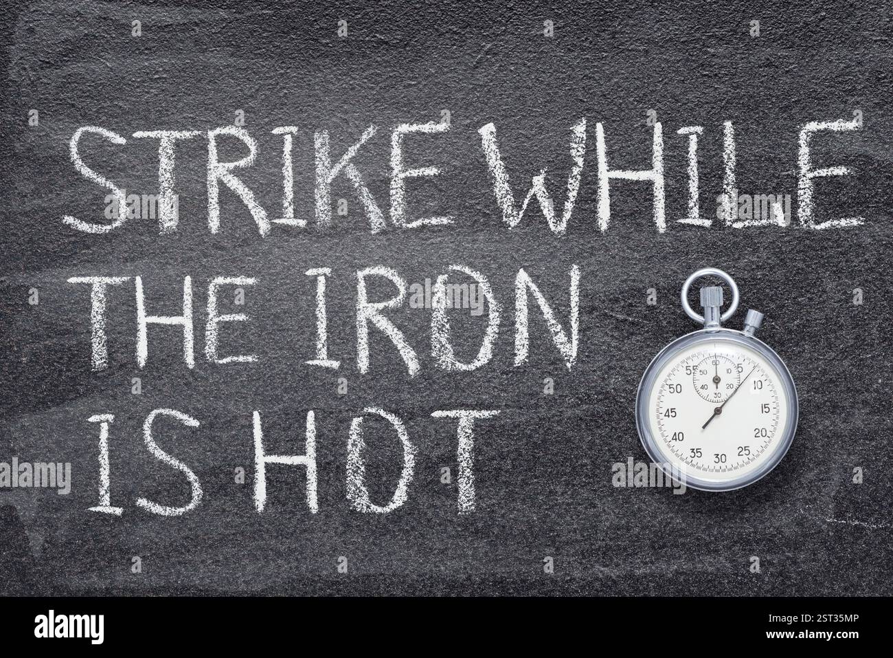 Strike while the iron is hot proverb written on chalkboard with vintage ...