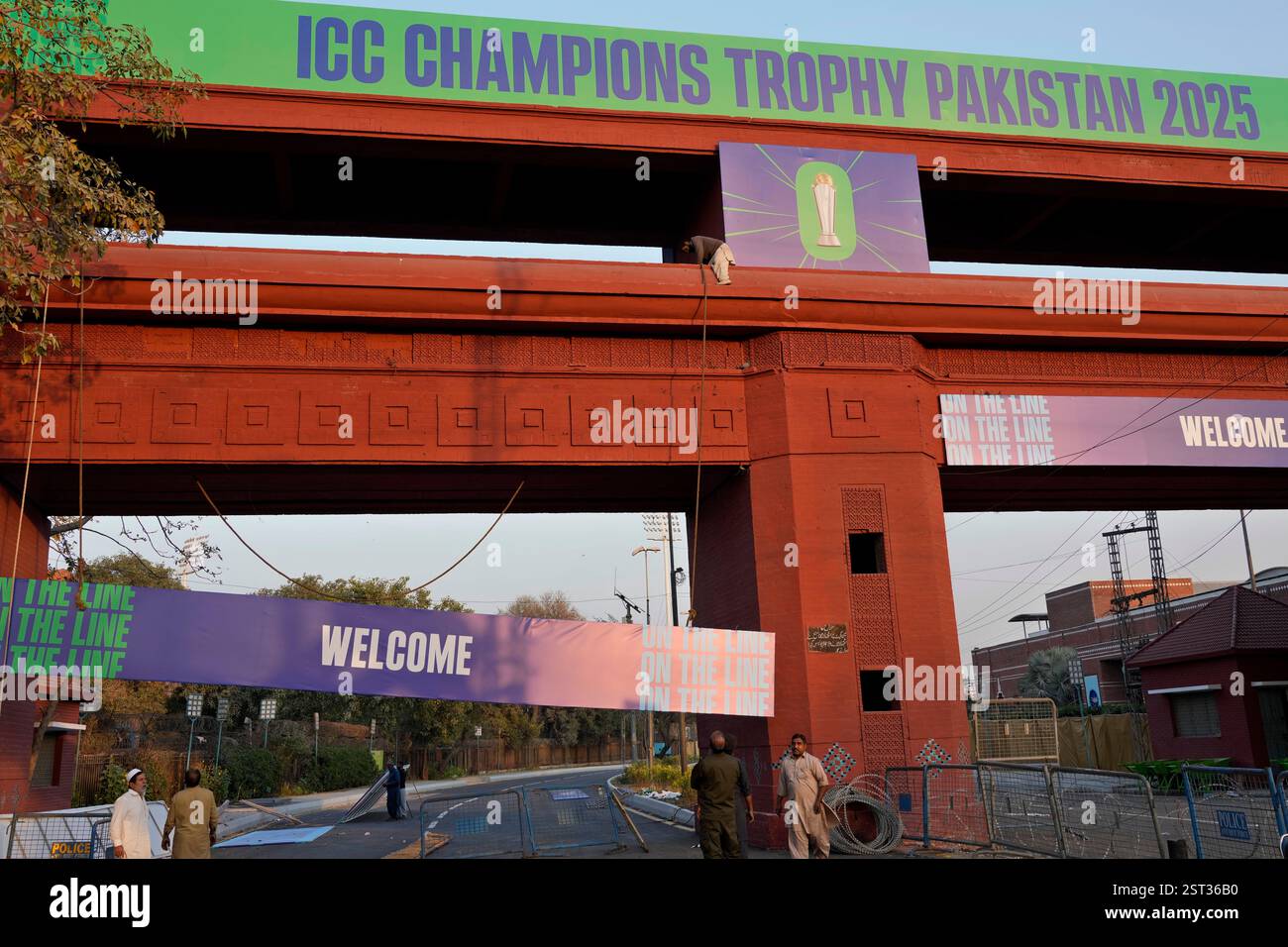 Workers install billboards on a structure of an entry point to Gaddafi ...