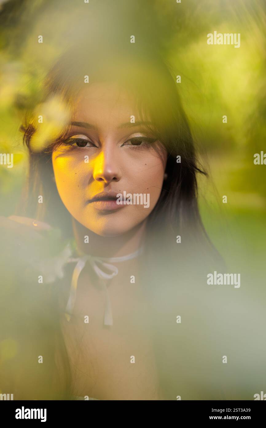 Beautiful Girl with long hair poses near white blossoming apple trees ...