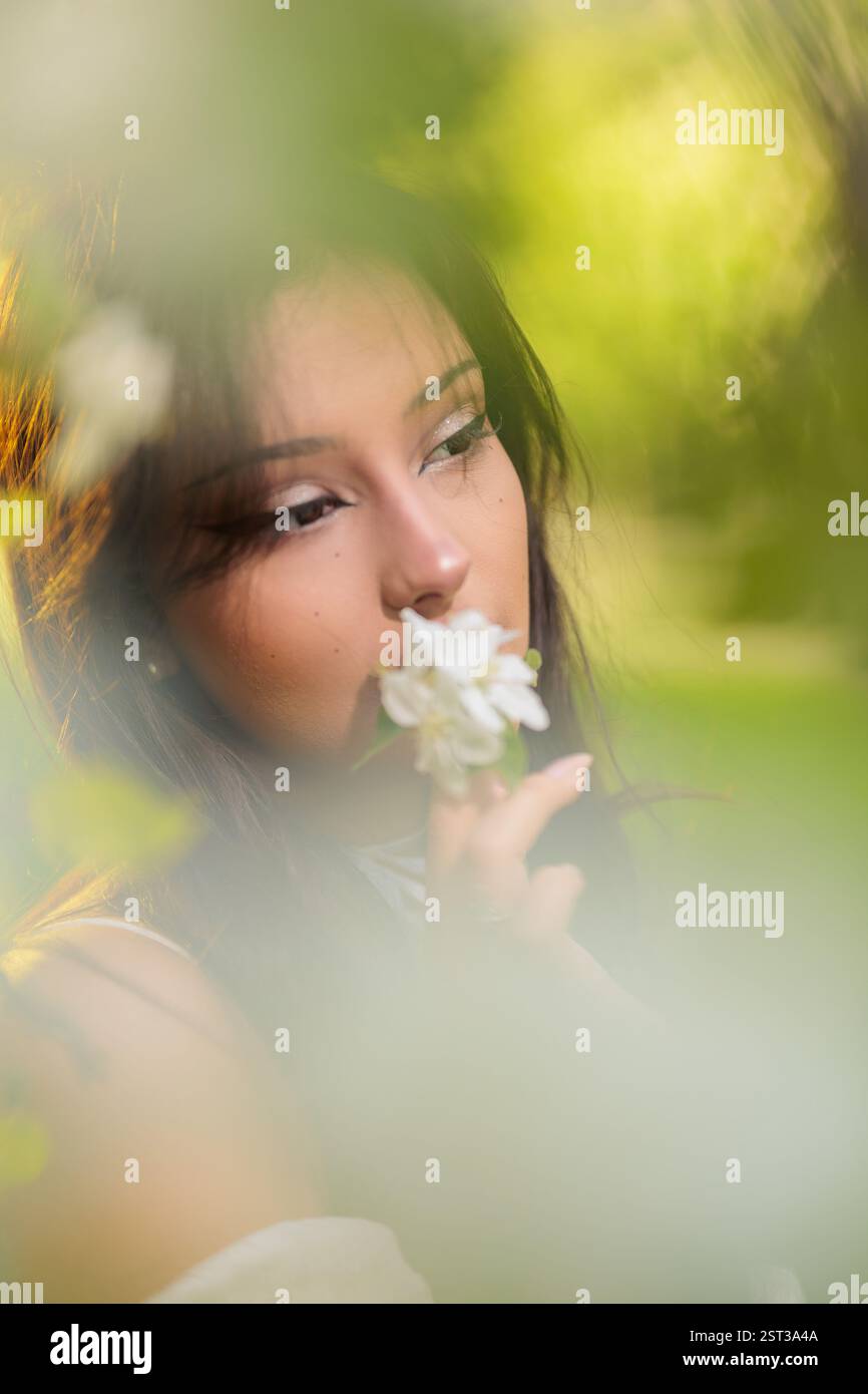 Beautiful Girl with long hair poses near white blossoming apple trees ...