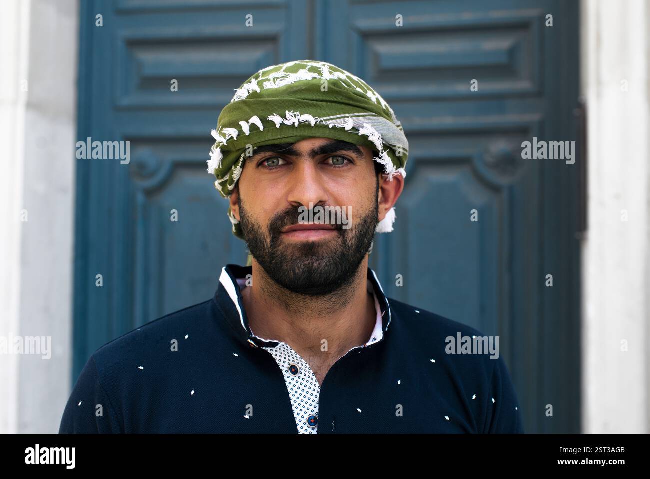 A Palestinian man stands confidently wearing a traditional headdress ...