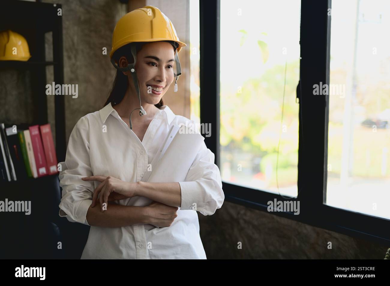 A confident, smiling Asian female architect or engineer boss, wearing a ...