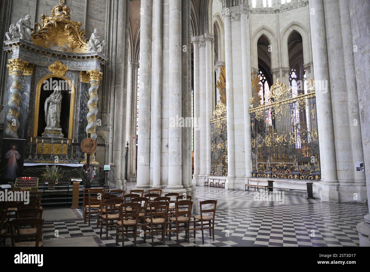 A marble statue of the Virgin Mary framed by ornate gold and marble ...