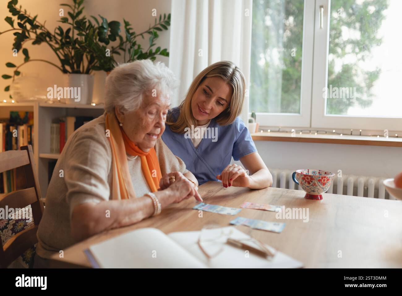 Social worker helping elderly lady with managing her finances, counting ...