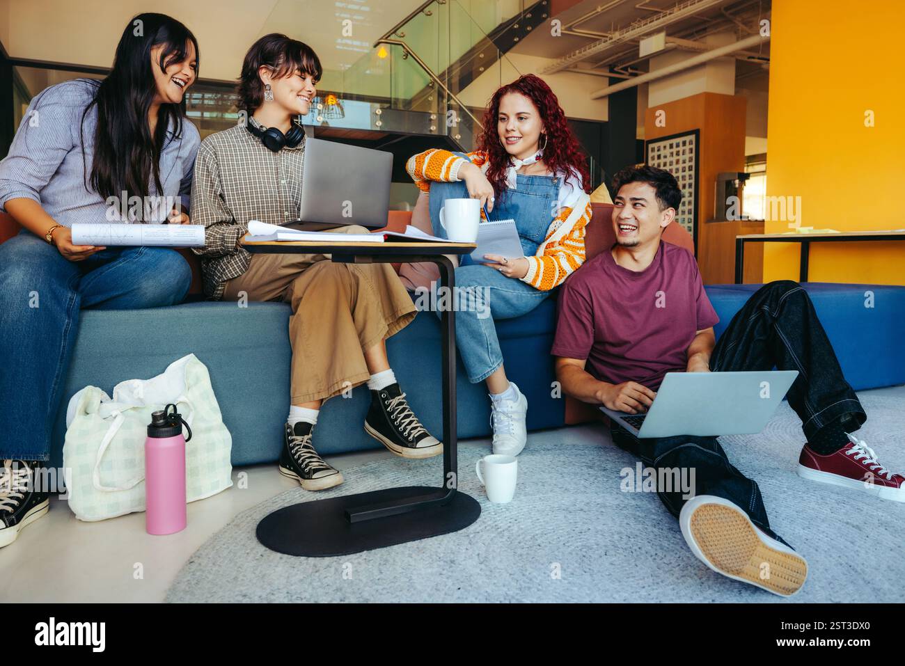 A diverse group of university students collaborate on group work in a ...